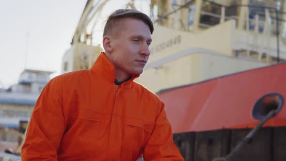 Harbor Master in Orange Uniform Sitting in Front of a Large Ship in ...