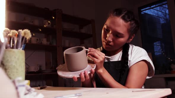 Pottery in the Studio Woman Holding a Cup on the Plate and Smearing ...