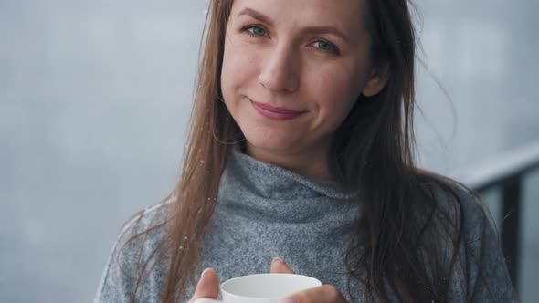 Woman Stays on Balcony During Snowfall with Cup of Hot Coffee or Tea ...