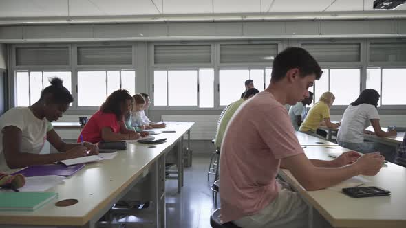 Teacher Walks in the Classroom Explaining Lesson to Class of Teenager ...