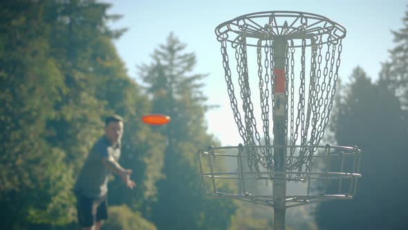 Man Throwing Disc Into Basket At Frisbee Golf Course, Stock Footage