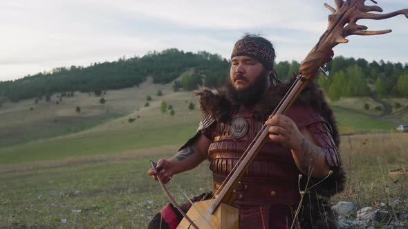 Calm Altai Music Player Ikili Stringed Instrument in Meadow, Stock Footage