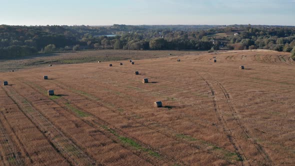 Beautiful morning flight over haystacks. The field is covered with hay ...