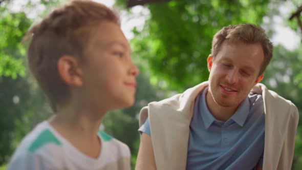 Munching Boy Laughing Talking with Father on Picnic, Stock Footage