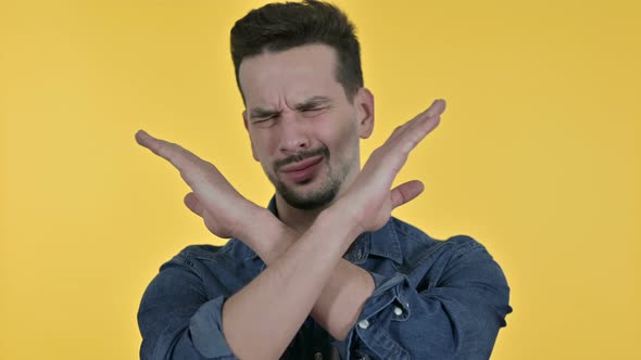 Portrait of Young Man Saying No By Hand Gesture, Yellow Background ...