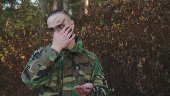 Brave Soldier in Camouflage Smears Soot Strips on Face at a Forest ...