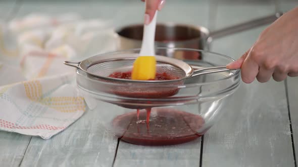 Woman Strains Berries Through a Sieve To Make Puree, Stock Footage