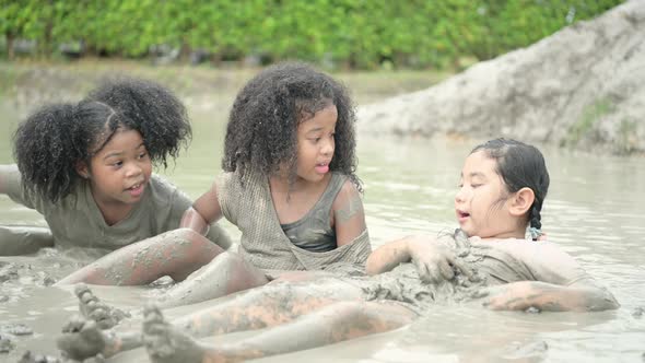 Children have fun playing in the mud in the community fields, Stock Footage