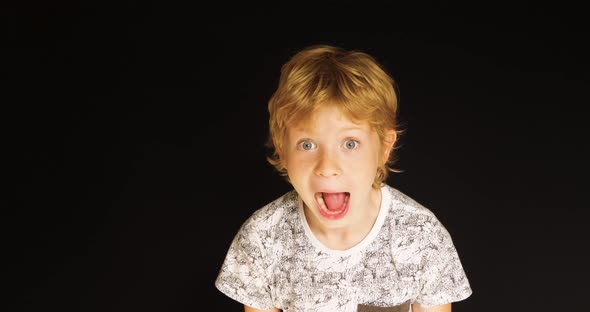 Young boy screams in front of black background, Stock Footage | VideoHive