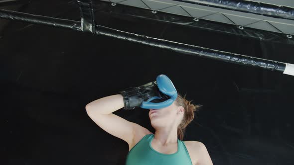 Top View of Tired and Sweaty Young Woman MMA Fighter Lying on Floor in ...