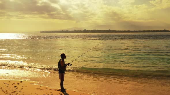 Male model fishing alone on luxury bay beach lifestyle by transparent ...