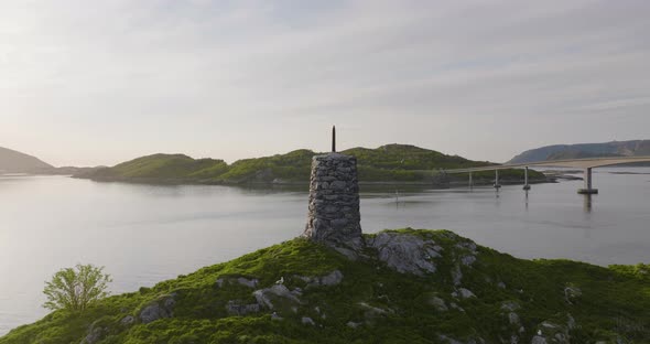 Rock stacked beacon nearby Sommaroy Bridge, sunset aerial arc, Kvaloya ...