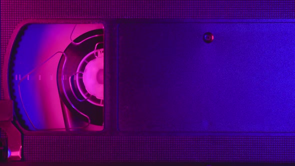 VHS cassette insert in the VCR, play, eject, closeup, blue and purple ...