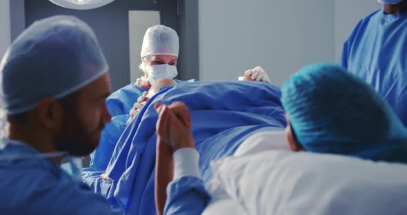 Caucasian female surgeon examining pregnant woman during labor in ...
