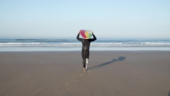 Back View of Man with Disability Going to Ocean with Surfboard, Stock ...