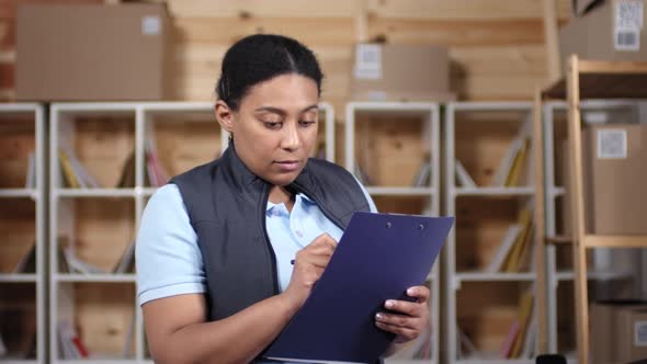 Attentive Black Female Post Office Employee Filling out Checklist ...