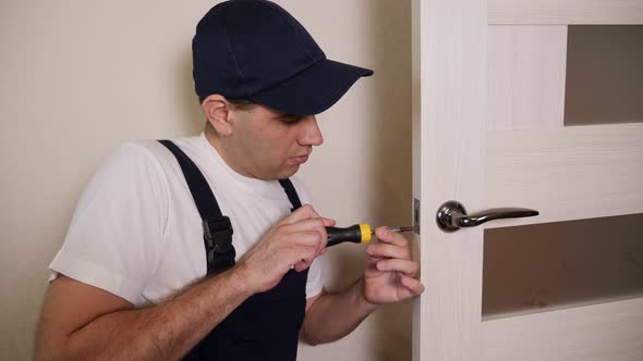 Portrait of Young Locksmith Workman in Blue Uniform Installing Door ...