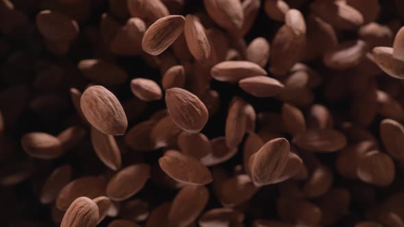 Almond flies after being exploded against black background. Slow Motion ...