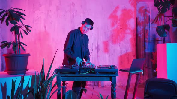 Modern DJ of Asian Appearance Performs a Music Track in Neon Lighting ...