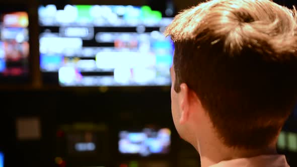 Rack focus close up perspective shot of man looking at television ...