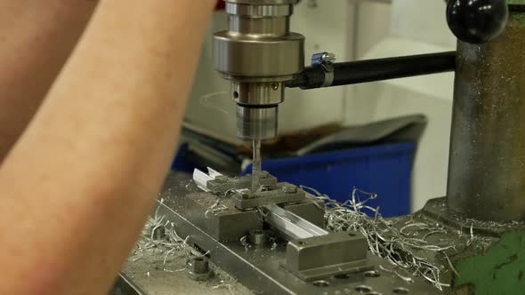 Worker making holes in metal plates with a punching drilling machine ...