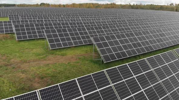 flying with drone closely over huge solar panel park in Europe Estonia ...