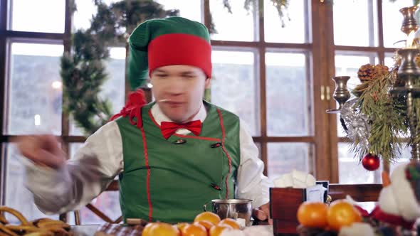Elf eating at a table. Santas elf eating Christmas dinner in a ...