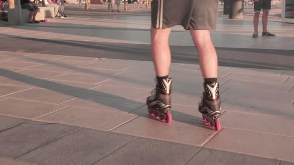 Slow motion, close up on person's feet roller blading on pavement ...