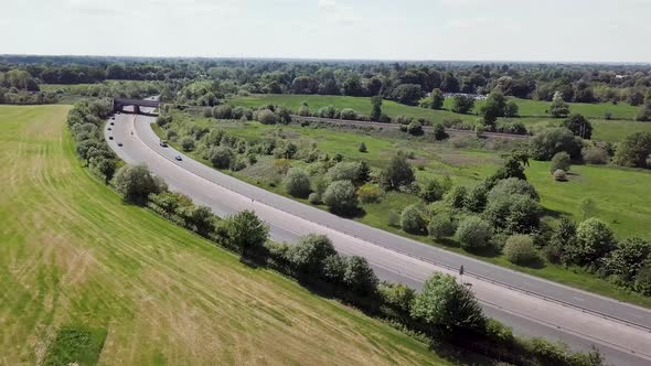 Drone flying over A34 trunk road which is intersected by a railway ...