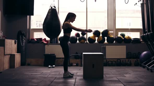 Attractive Sportive Girl in Her 20's Jumping Up on Cubicle at the Gym ...