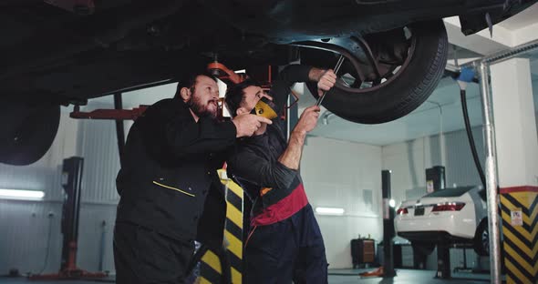 In a Modern Auto Service Center Two Mechanic in, Stock Footage | VideoHive