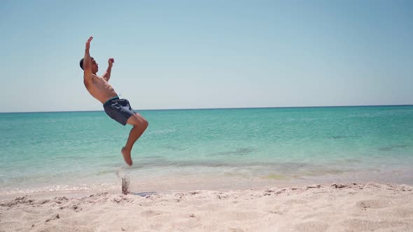 Athletic Man Doing Back Flip on Sea Beach, Stock Footage | VideoHive