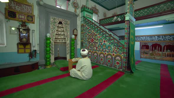 Muslim Mosque Teacher is reading the Quran in Small Historic Wooden ...