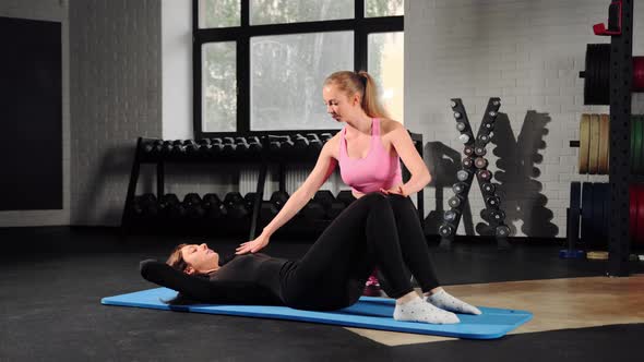 Coach woman training girl during abs exercise in the gym, Stock Footage