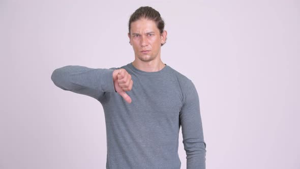 Angry Man Giving Thumbs Down Against White Background, Stock Footage