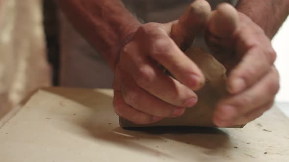 Rough Hands of Artisan Potter Crumple and Roll Clay on Table Front View ...
