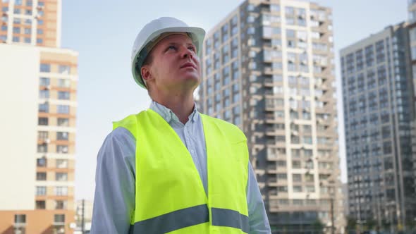 Engineer Looking Up at Buildings in New City District, Stock Footage