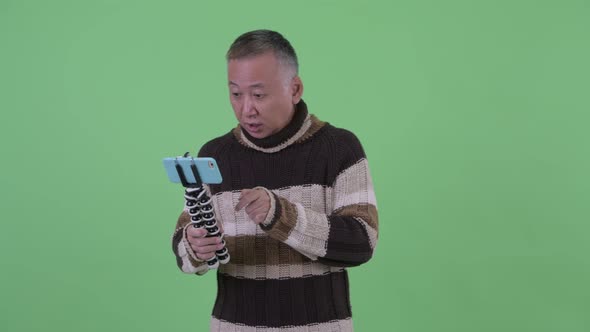 Happy Mature Japanese Man Vlogging and Showing Phone, Stock Footage
