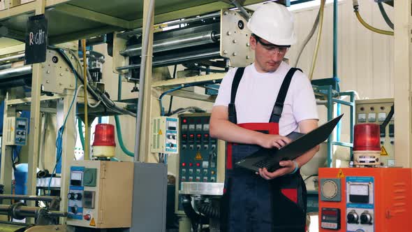 Factory Worker Using His Laptop To Control Plastic Bag Manufacturing ...