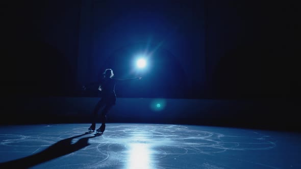 Young Figure Skating Artist Rotates on Ice Arena in Dark Against ...