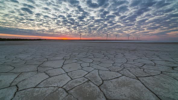 Wind Turbines in Desert with Cracked Earth at Sunrise, Stock Footage
