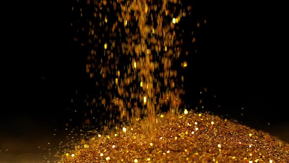 Gold Powder falling against Black Background, Slow motion, Stock Footage