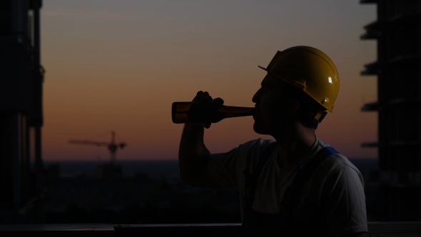 Construction worker drinking beer in helmet., Stock Footage | VideoHive