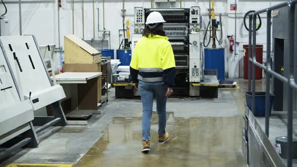 Back View of Female Machine Operator Walking at Factory, Stock Footage