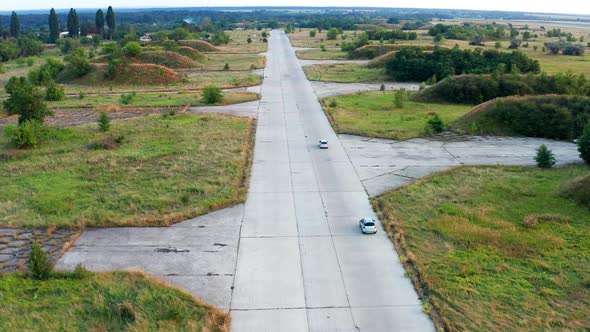 Flying over a car that is traveling on an airplane runway., Stock Footage
