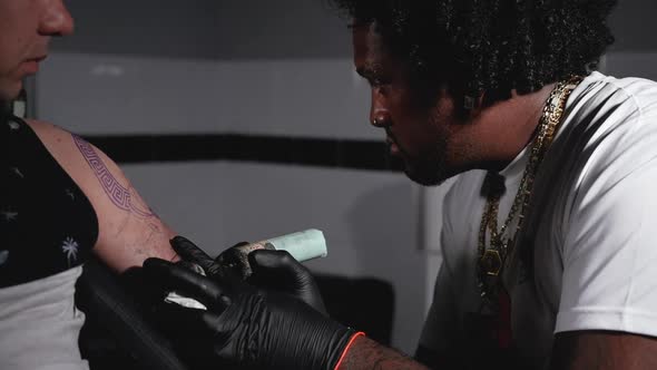 Cinematic Slow Motion Shot of a Tattoo Artist Creating Body Art at the ...