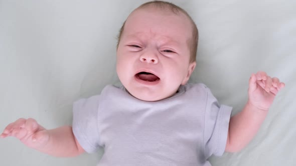 Dissatisfied Crying Upset Sad Newborn Baby Boy Lying in Nursery in Crib ...