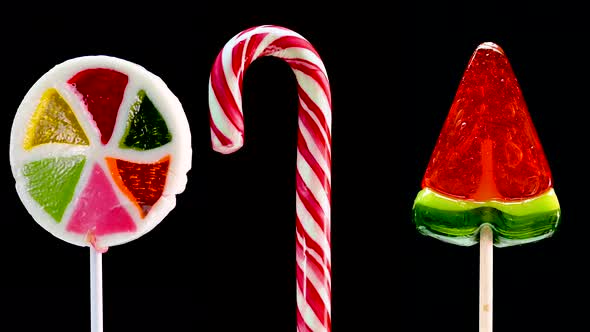 Various Lollipops Rotate On A Black Background. Candy Cane, Stock Footage