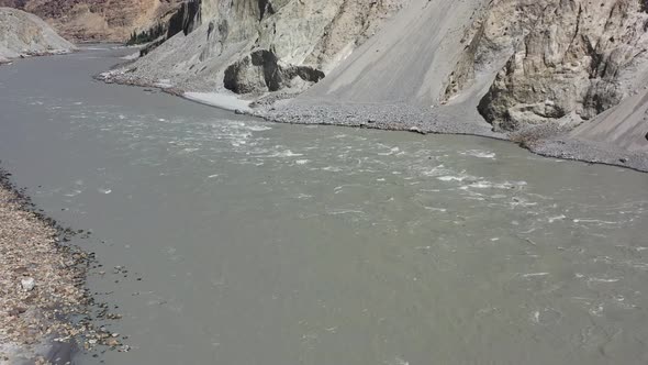 aerial drone panning left over the Indus River Valley as rapids flow ...