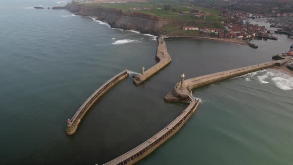 Aerial shot of Whitby east and west pier lighthouses and harbor ...